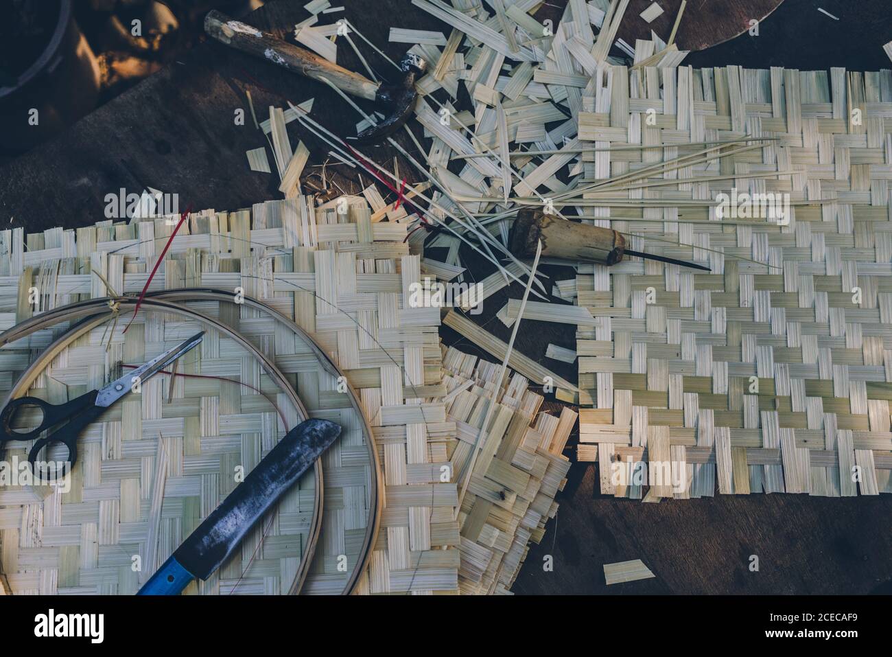 View from above of woven leafs from straw leaves with awl, scissors ...
