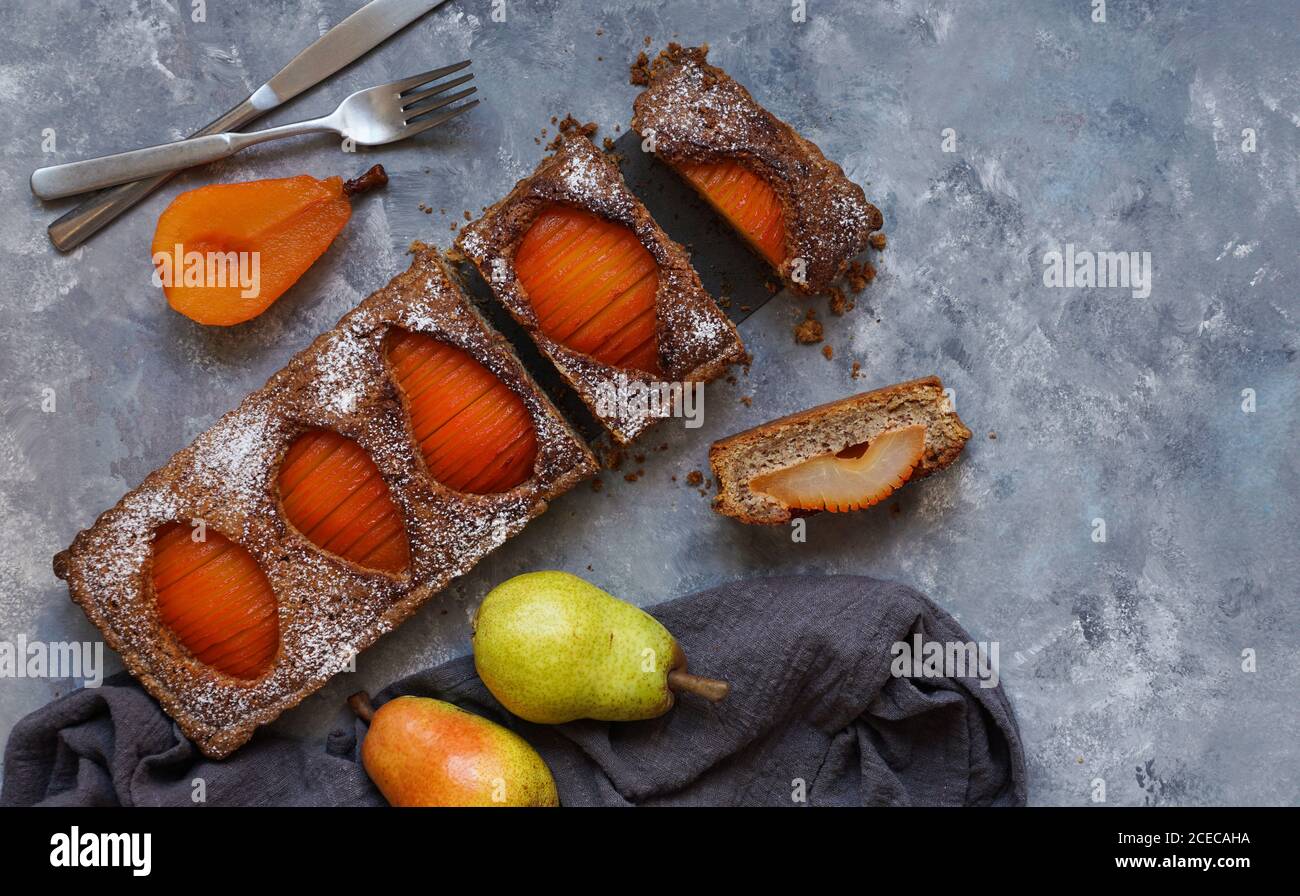 From above cutlery and pear frangipane tart near fresh fruits and ...
