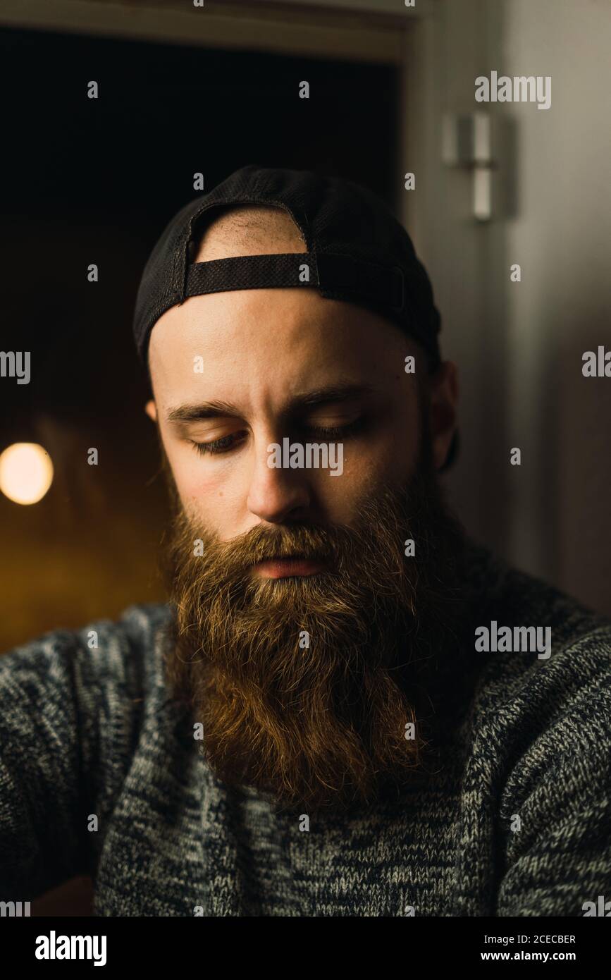 Bearded man in cap posing inside Stock Photo - Alamy