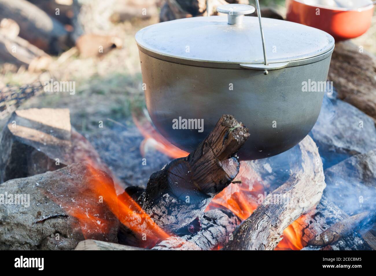 Bonfire and metal cauldron. Cooking on open fire, camping meal Stock ...