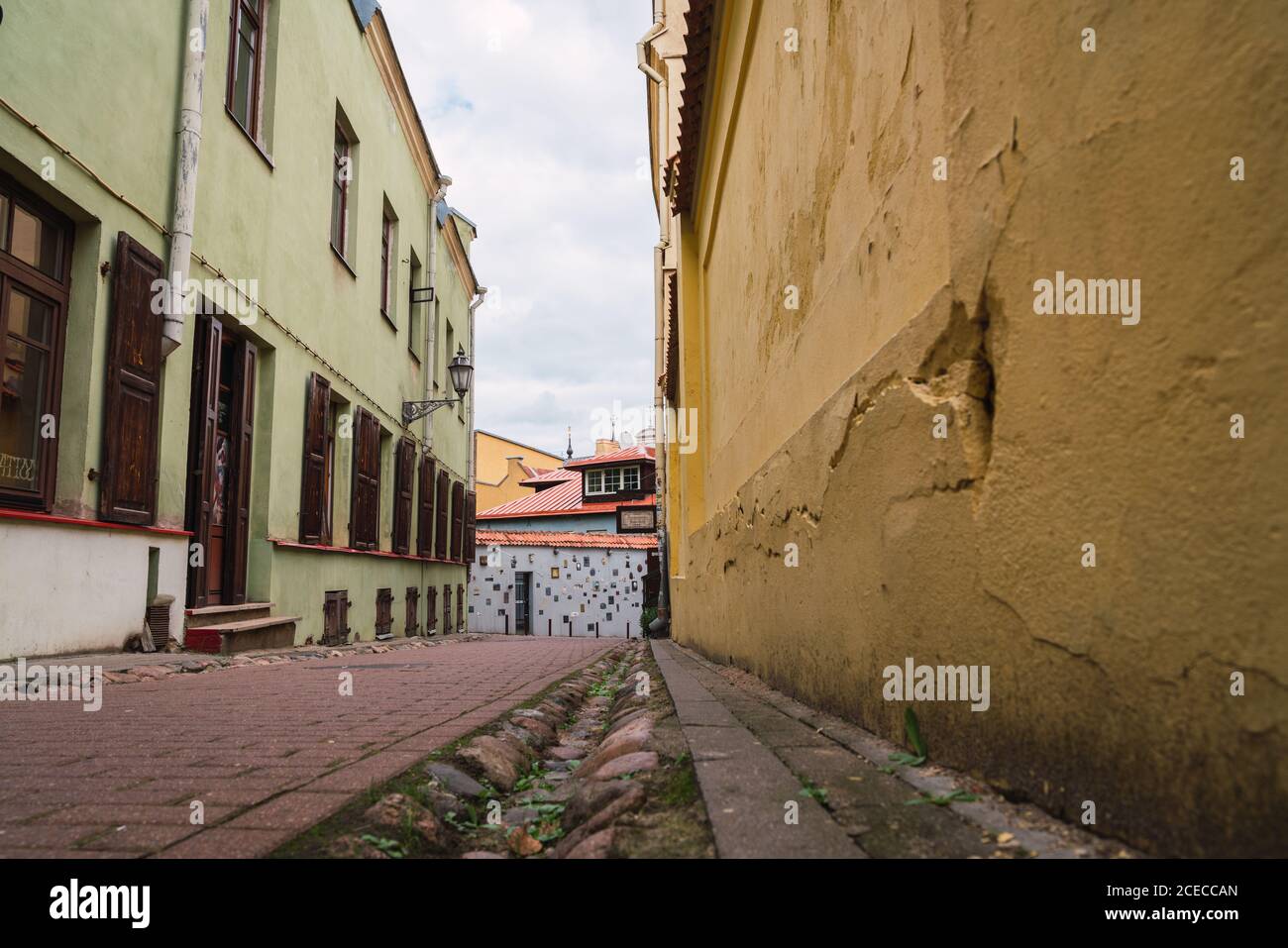 Brick pavement between two†lovely buildings on narrow street of small ...