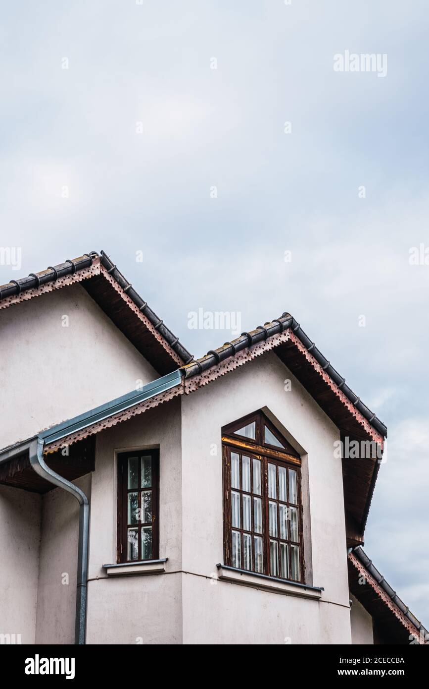 Walls and roof of luxury countryside house against blue overcast sky ...