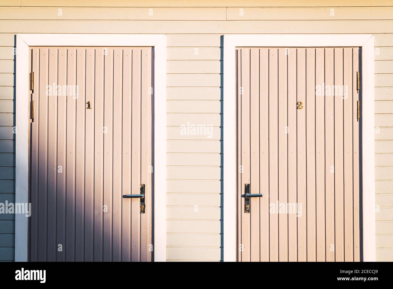 Two lovely doors with numbers on facade of modern residential building ...