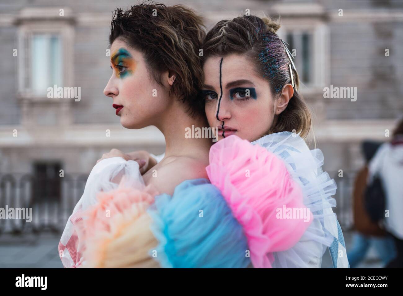 side view of Two young women with theatrical makeup and unusual clothes ...