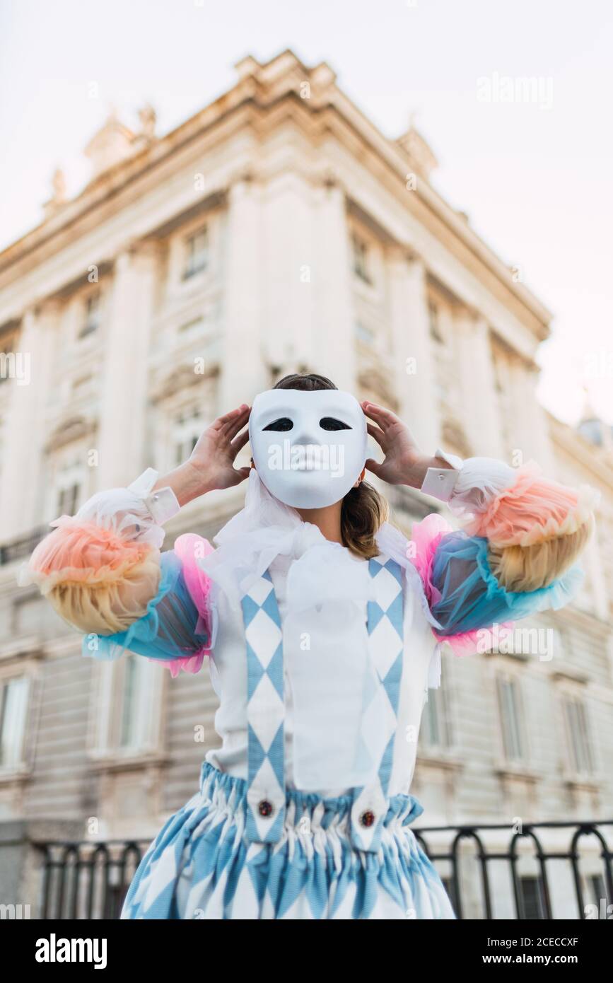 anonymous young Woman wearing theatrical costume and white mask while ...