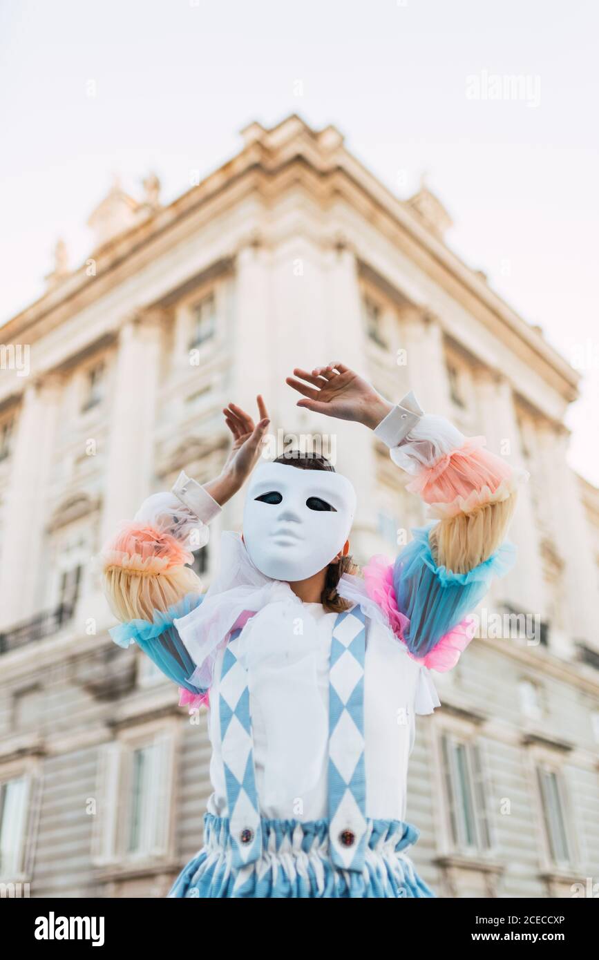 anonymous young Woman wearing theatrical costume and white mask while ...