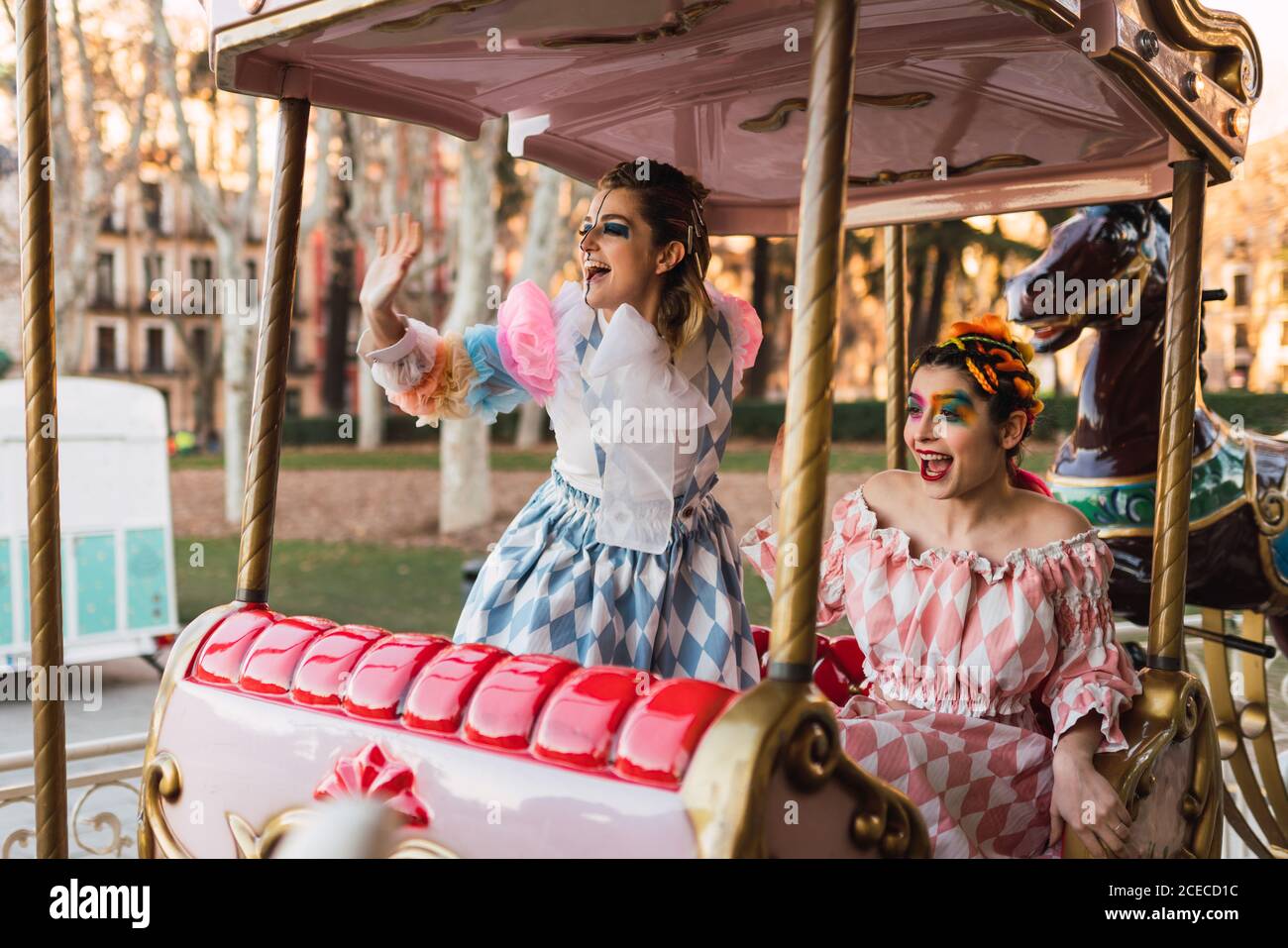 Two pretty young women with theatrical makeup and costumes laughing ...