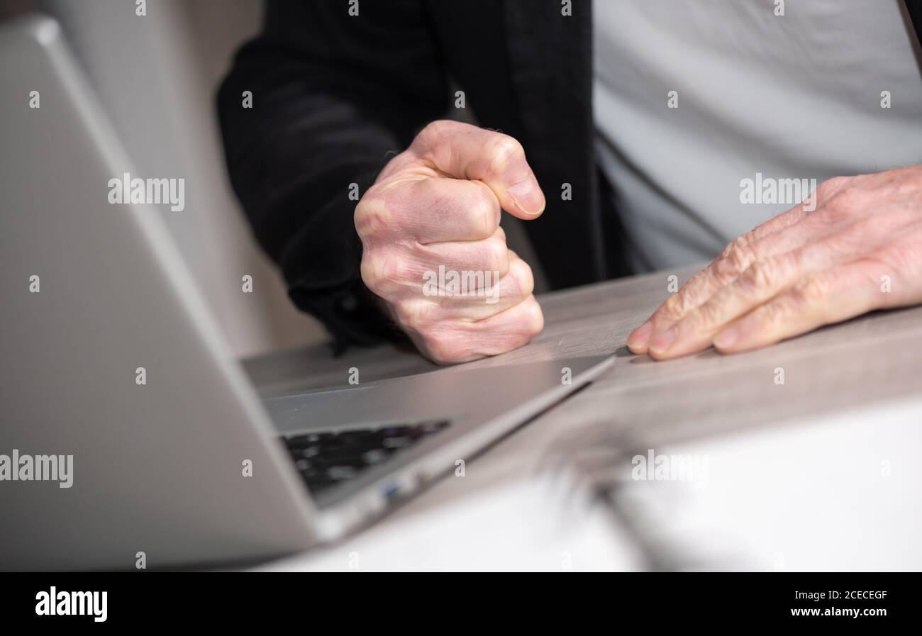 Angry businessman hitting his desk with his clenched fist Stock Photo ...