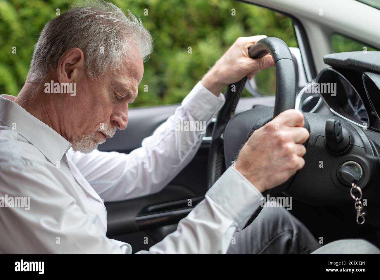 Tired senior man falling asleep behind steering wheel of car Stock ...