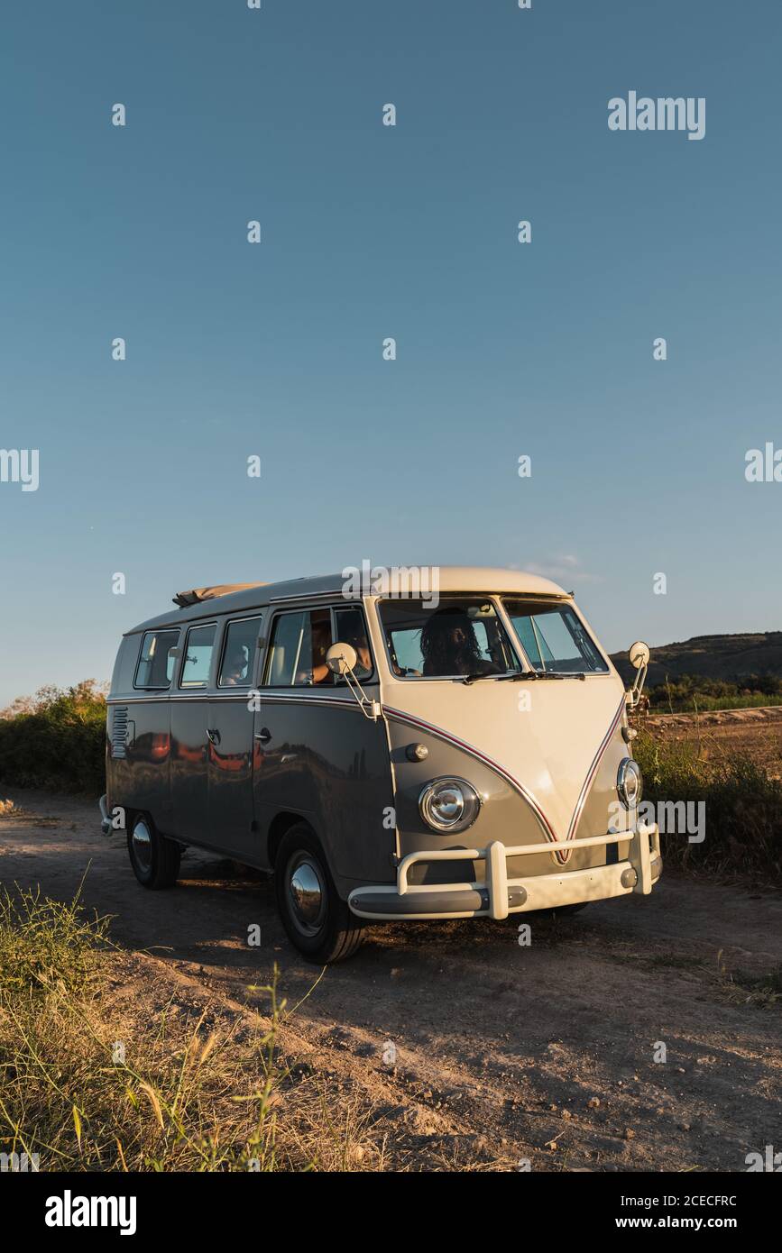 Cute vintage van standing on narrow countryside road on background of ...