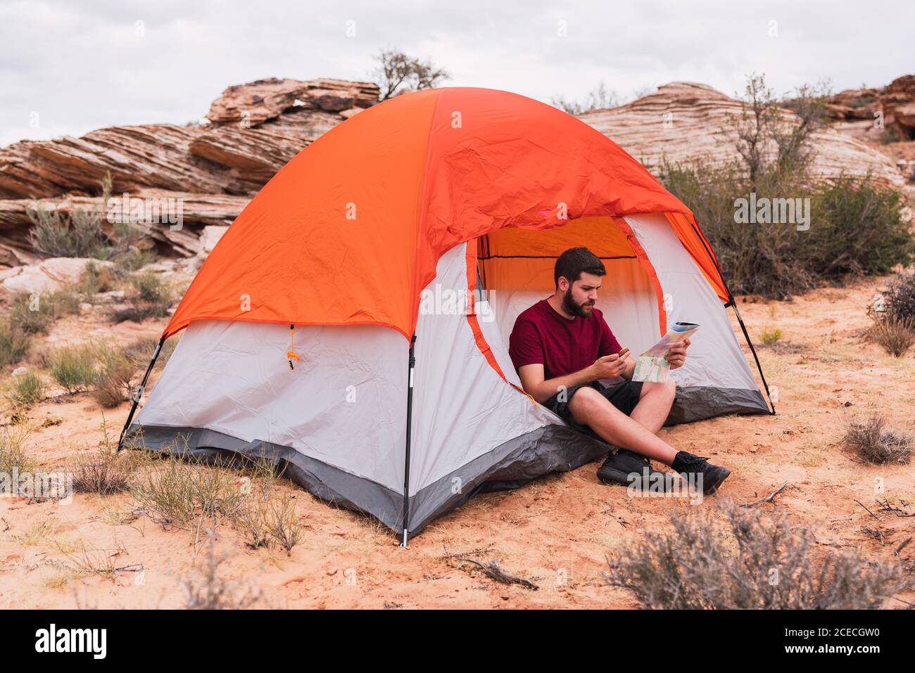 Traveler using map and compass at tent Stock Photo - Alamy