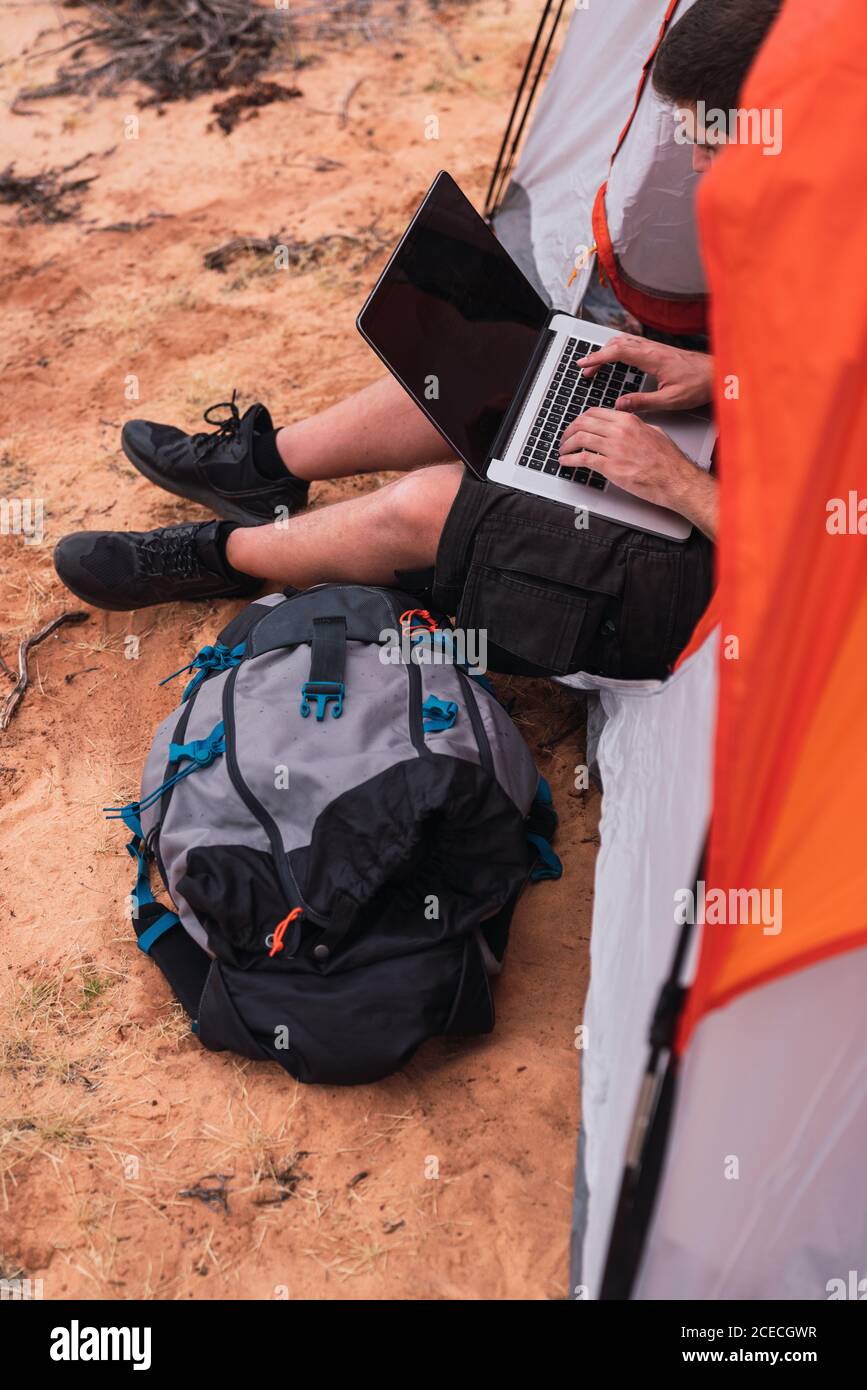 Traveler using laptop into a tent Stock Photo - Alamy