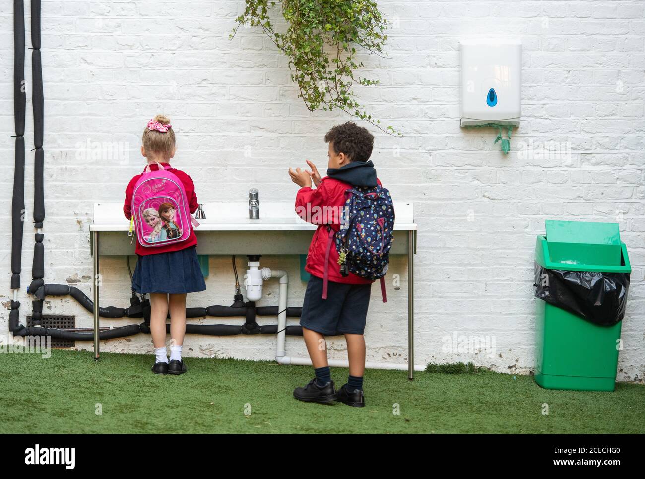 Pupils wash their hands as they arrive on the first day back to school ...