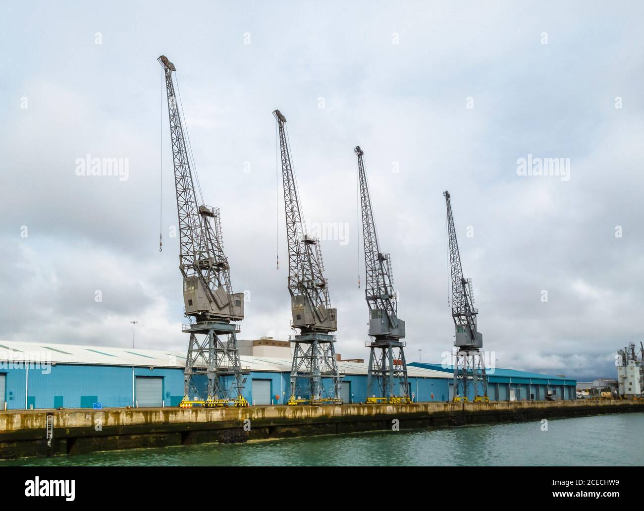 Row of 4 moveable gantry cranes on the waterside of the docks at the ...