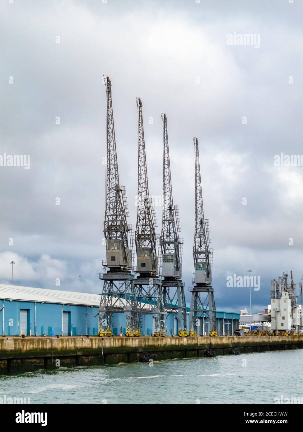 Row of 4 moveable gantry cranes on the waterside of the docks at the ...