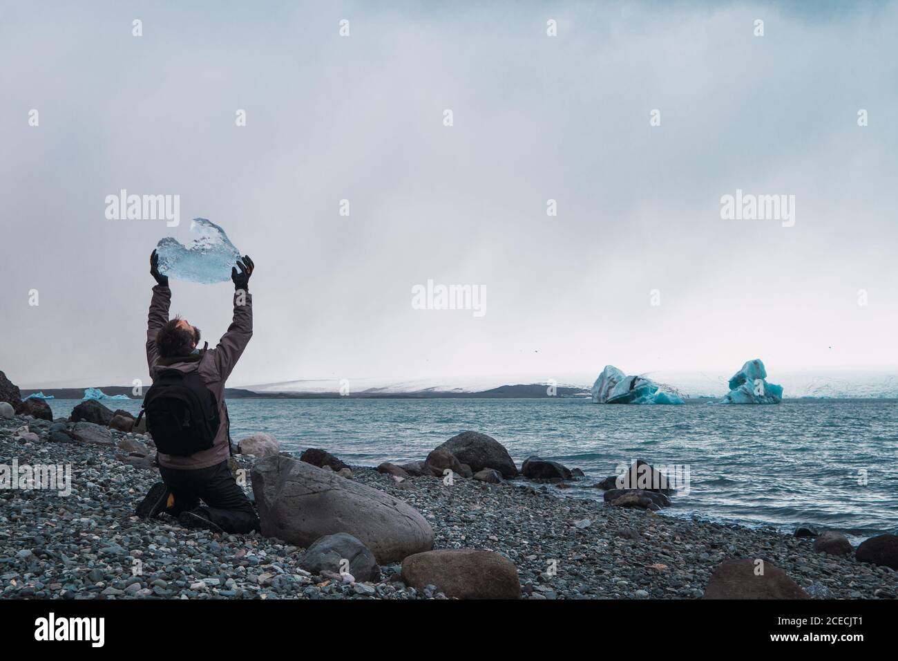 Cheerful man with piece of ice Stock Photo - Alamy