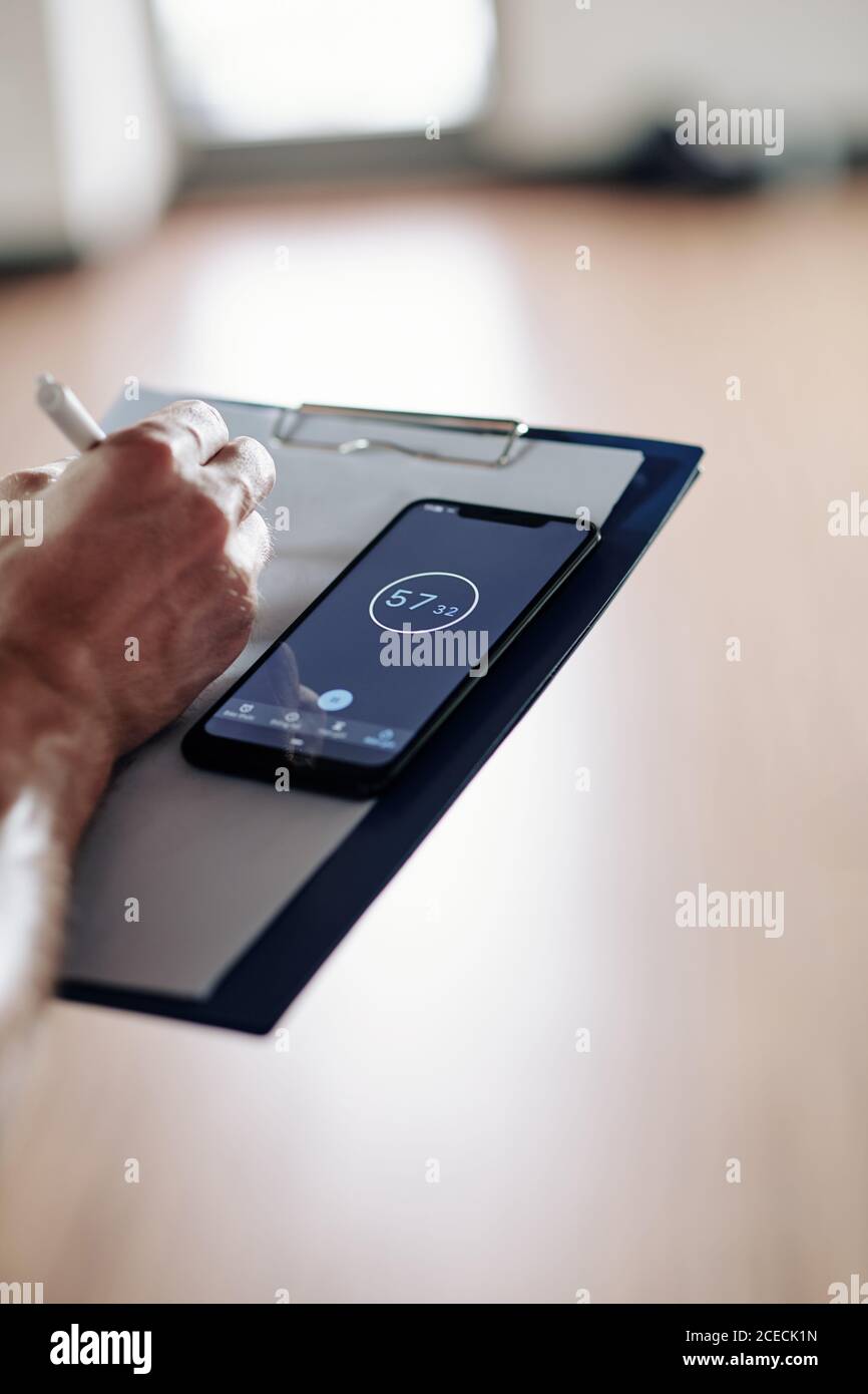 Fitness trainer checking stopwatch Stock Photo - Alamy
