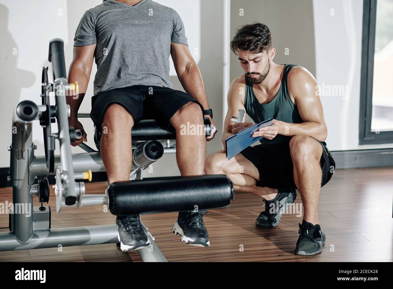Exercising in leg extension machine Stock Photo - Alamy