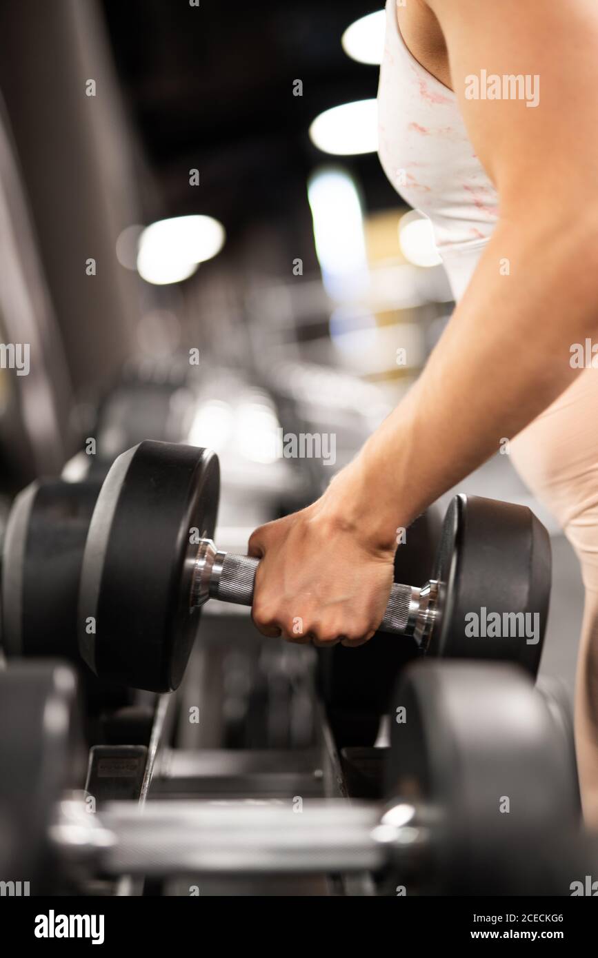Woman taking dumbbell in gym Stock Photo - Alamy