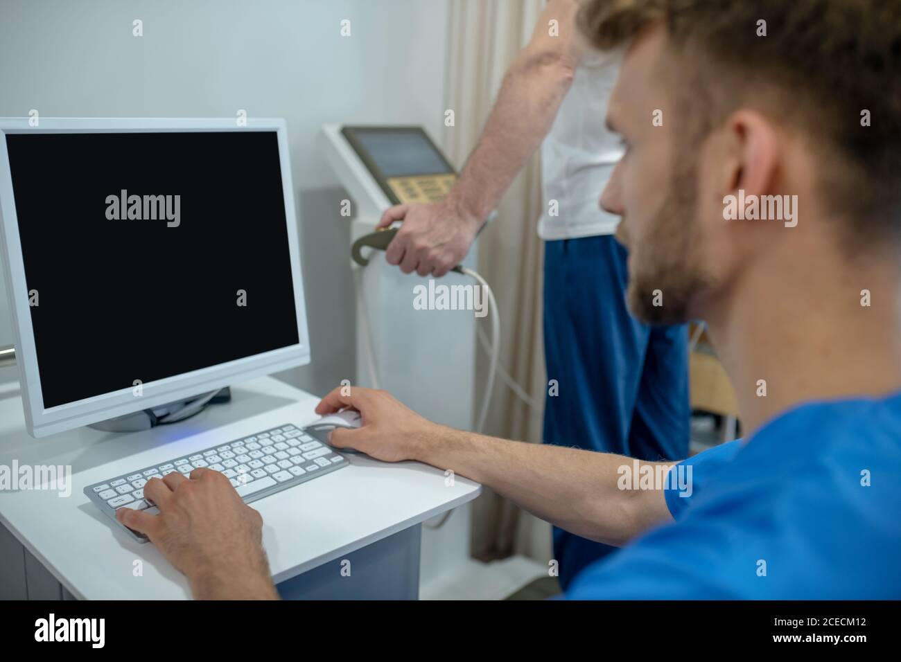 Bearded doctor checking results of exercise stress test on the screen ...
