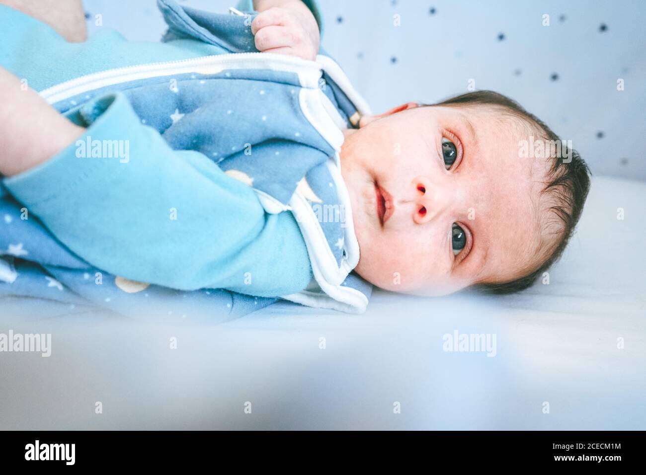 Lovely and curious newborn lying down in her little bed Stock Photo - Alamy