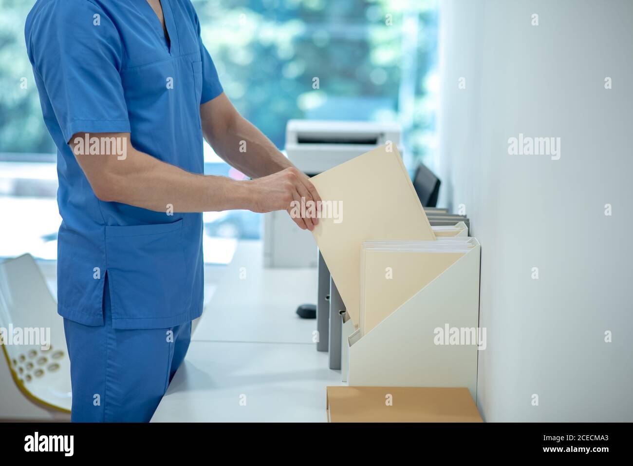 Medical worker in blue suit with document Stock Photo - Alamy
