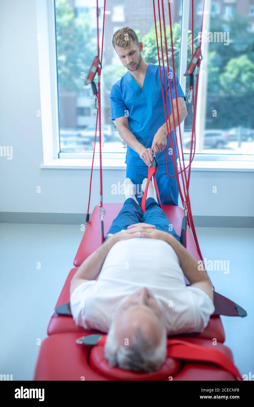Male physician preparing patient for rehabilitation procedure Stock ...