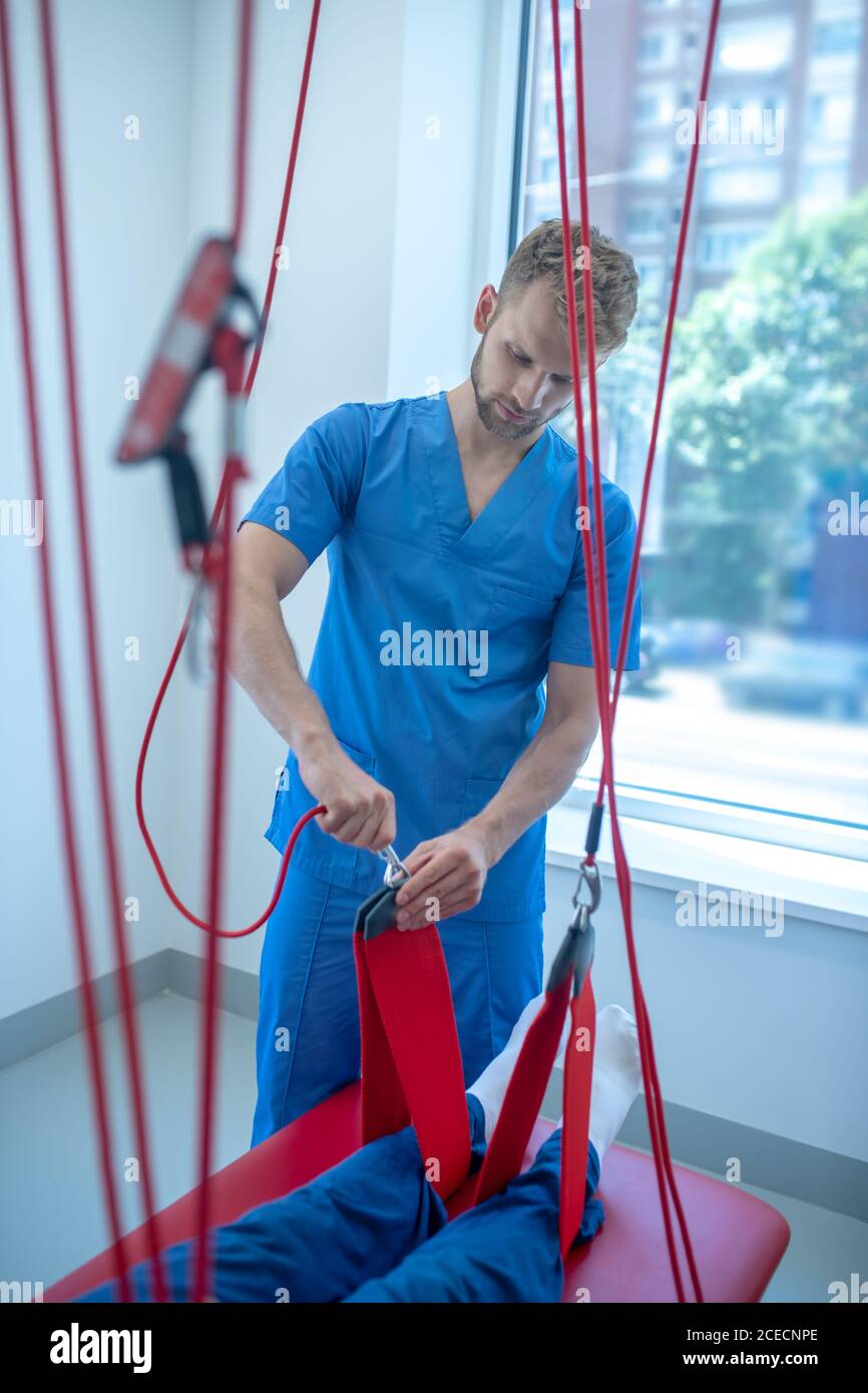 Male doctor hanging training strap at medical center Stock Photo - Alamy