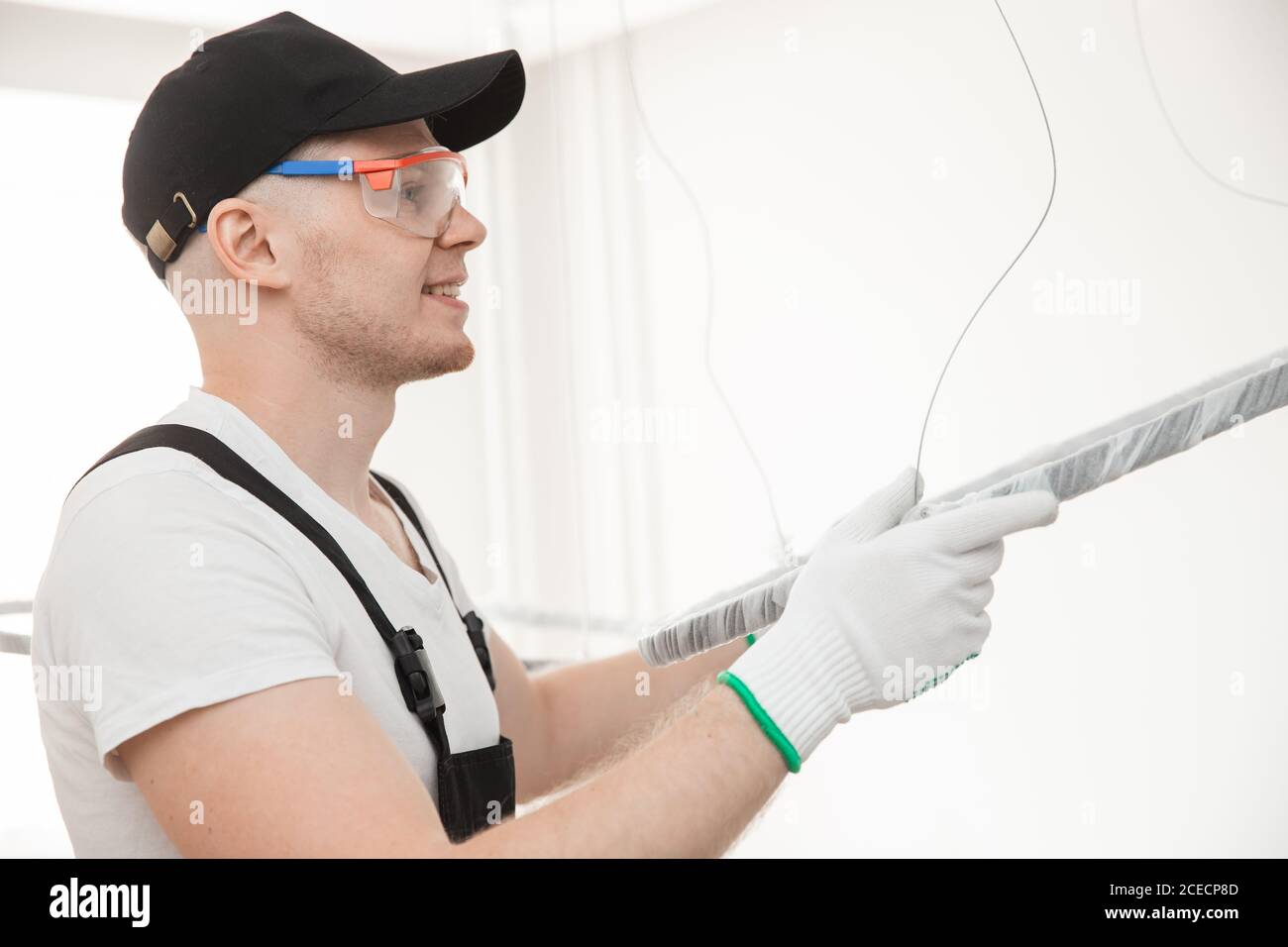 Electrician worker man assembling electric lamps in new apartment Stock ...