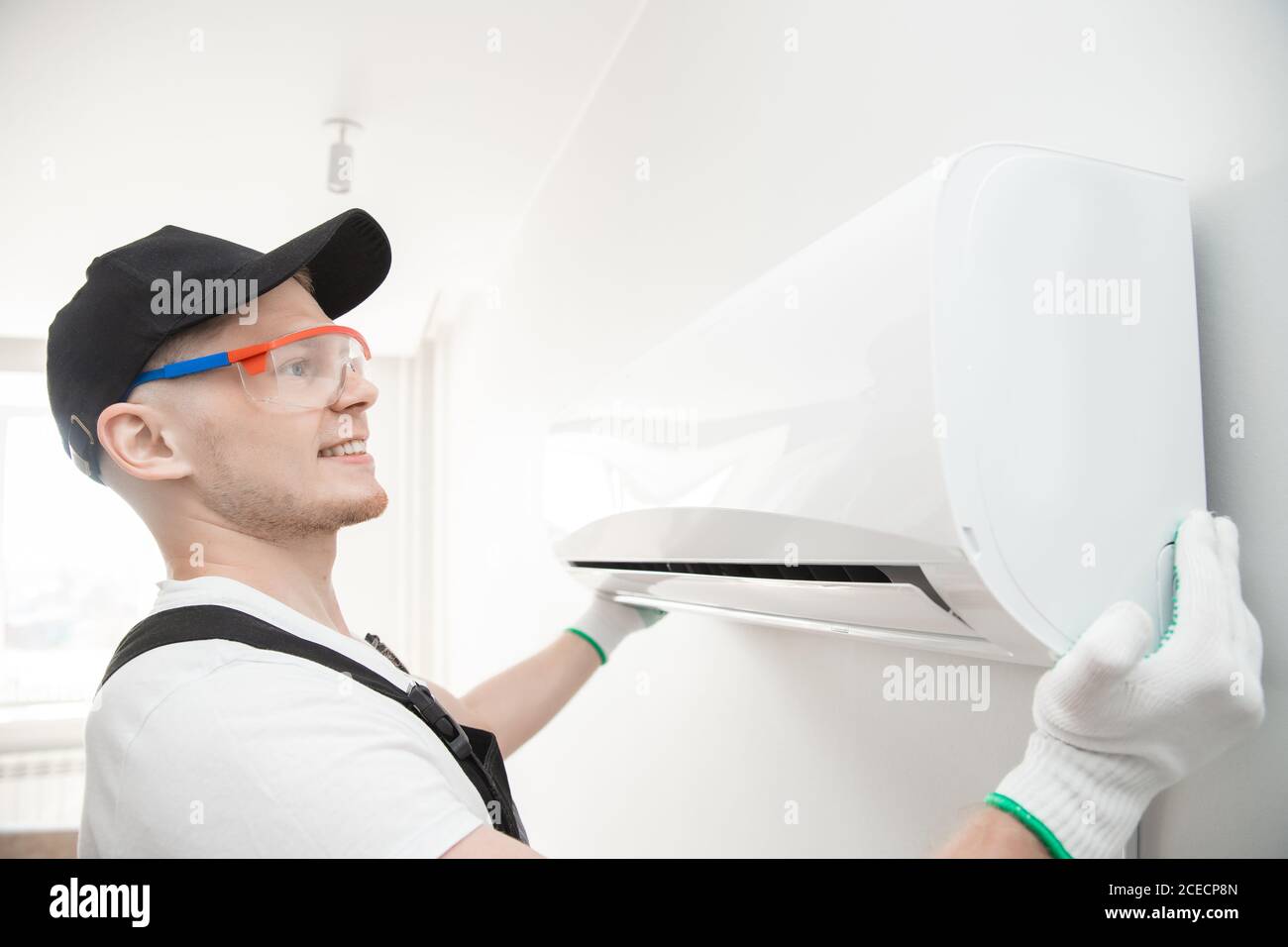 Installs air conditioner Worker man white wall Stock Photo - Alamy