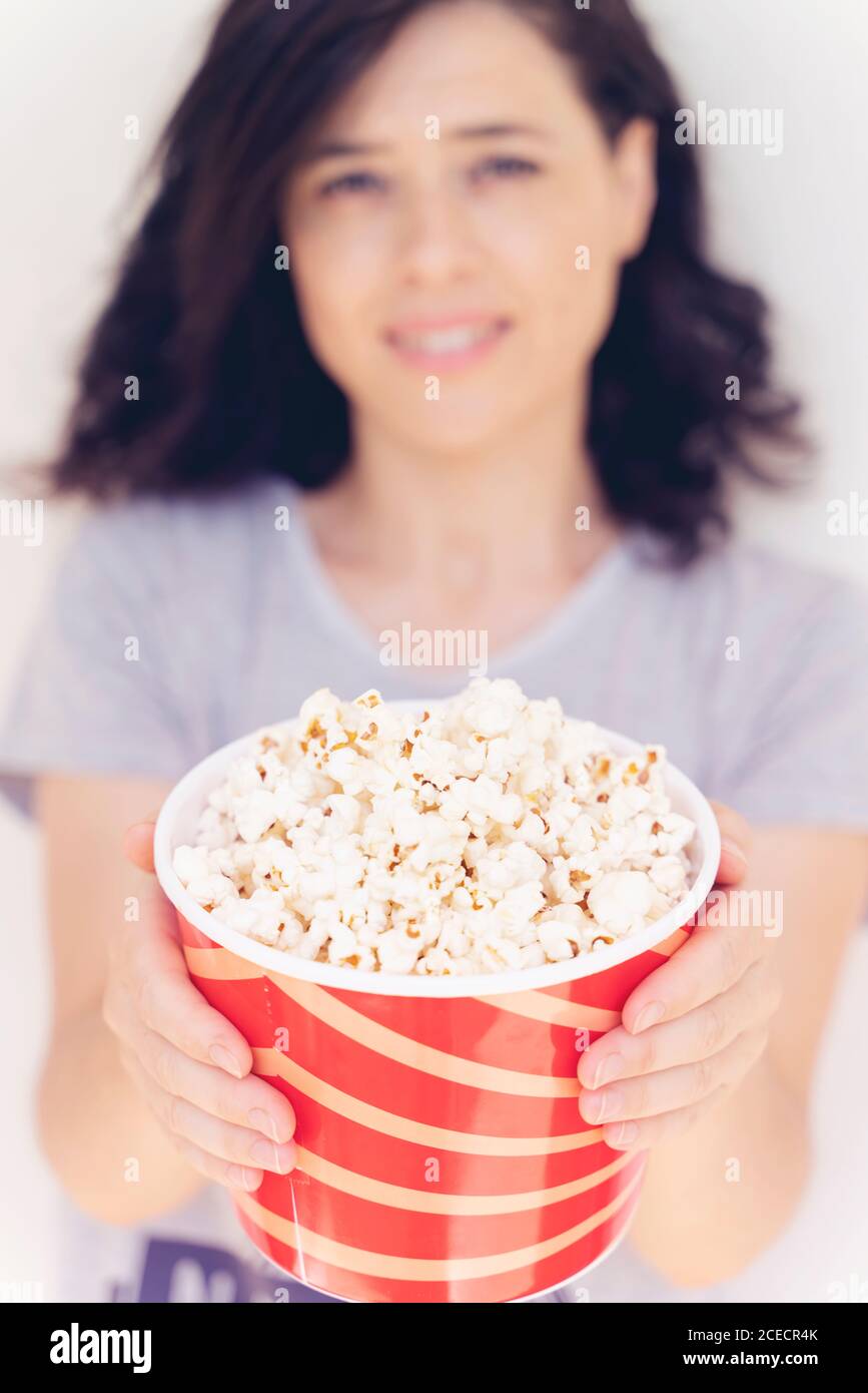 Closeup on bucket with popcorn in hand of young woman Stock Photo - Alamy