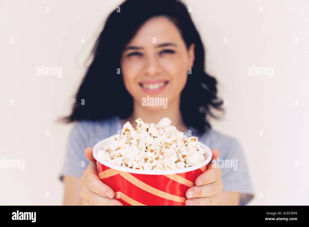 Closeup on bucket with popcorn in hand of young woman Stock Photo - Alamy