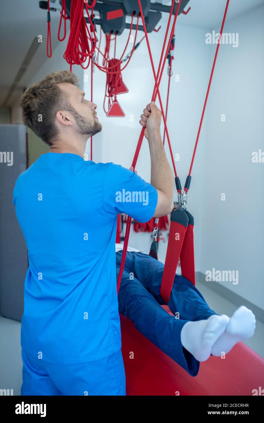 Doctor pulling up hanging straps with his hands Stock Photo - Alamy