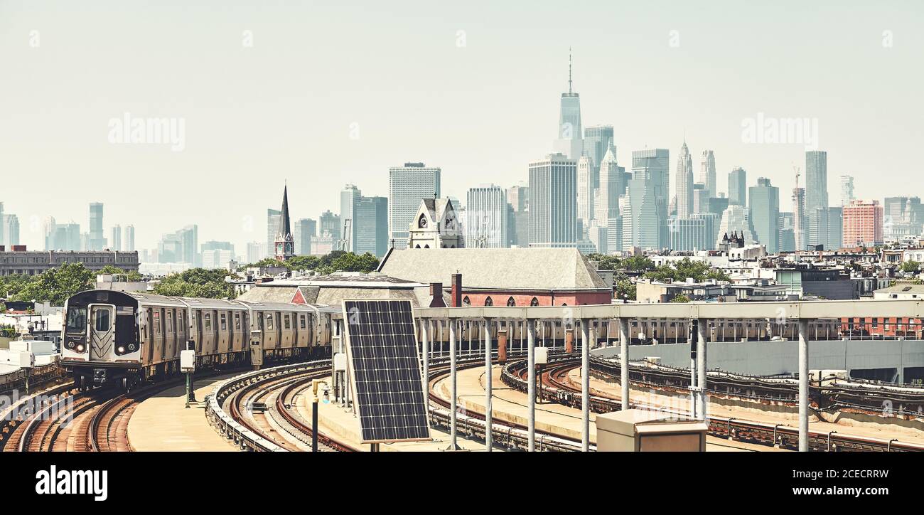 New York subway train with Manhattan skyline in background, color toned ...