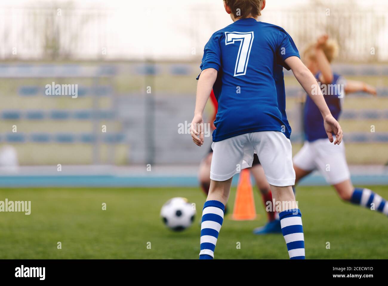 Back of young soccer boy playing game on grass school field. Young ...