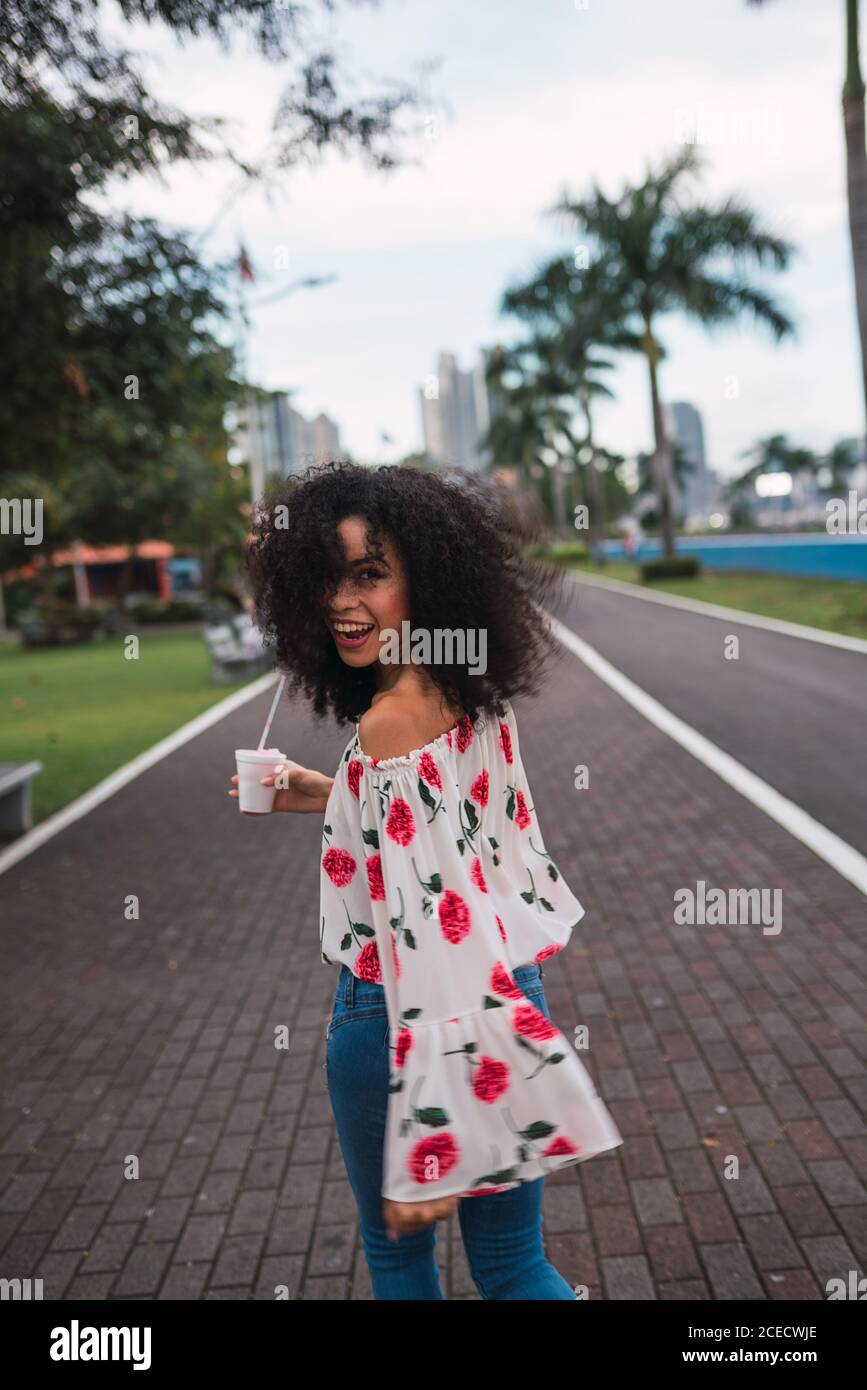 Bright ethnic Woman spinning around in park Stock Photo - Alamy