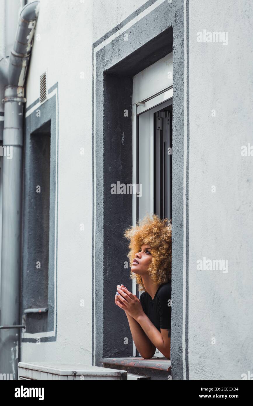 Leaning out of window exterior hi-res stock photography and images - Alamy
