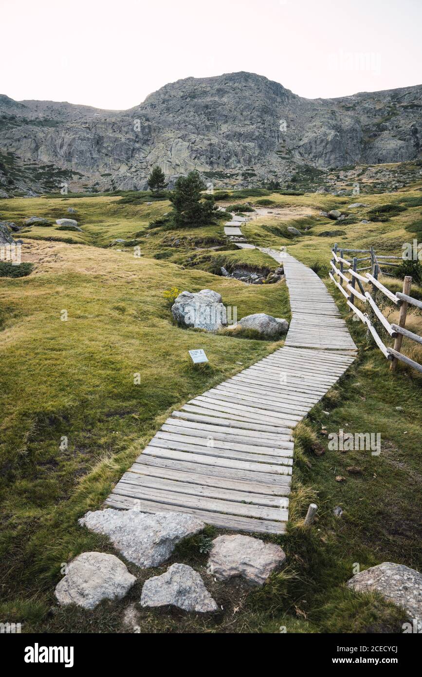 Perspective view wooden walkway rocky green terrain mountains ...