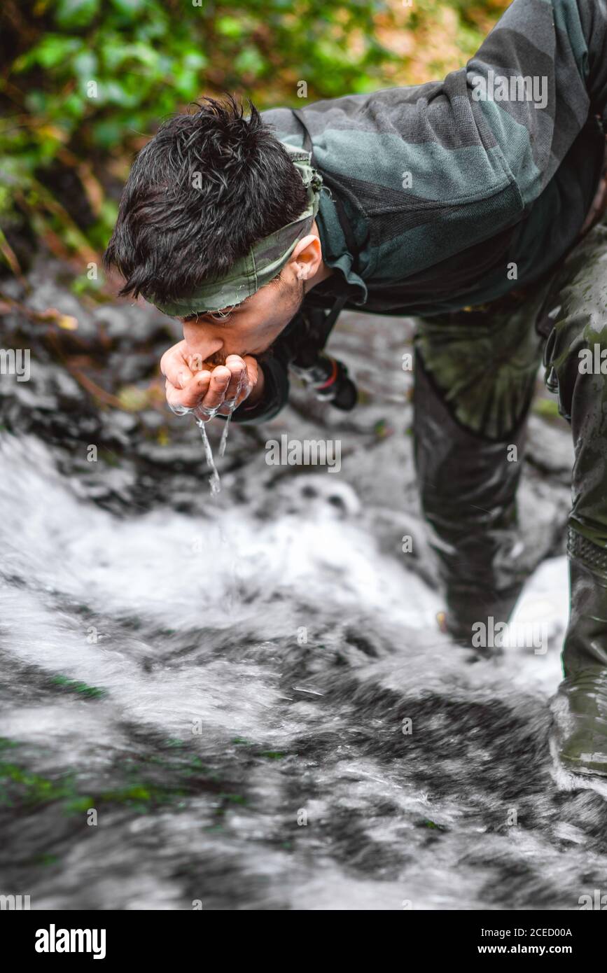 Soldier or revolutionary member or hunter in camouflage near the stream ...