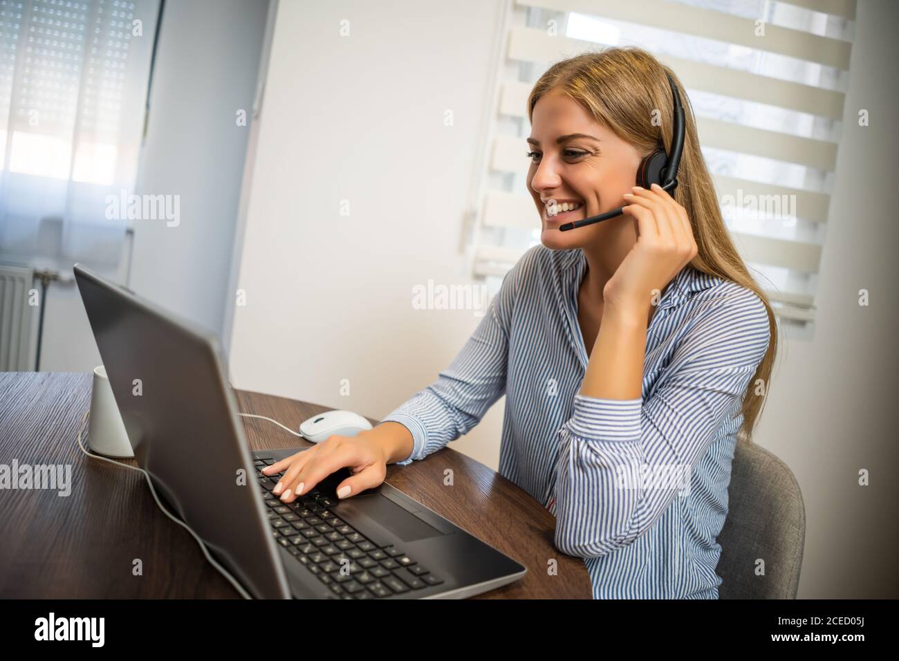 Young modern woman is working from home. Online operator working at ...