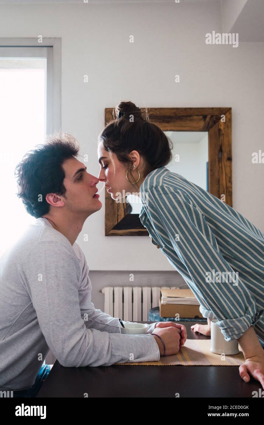 Affectionate couple kissing table hi-res stock photography and images ...