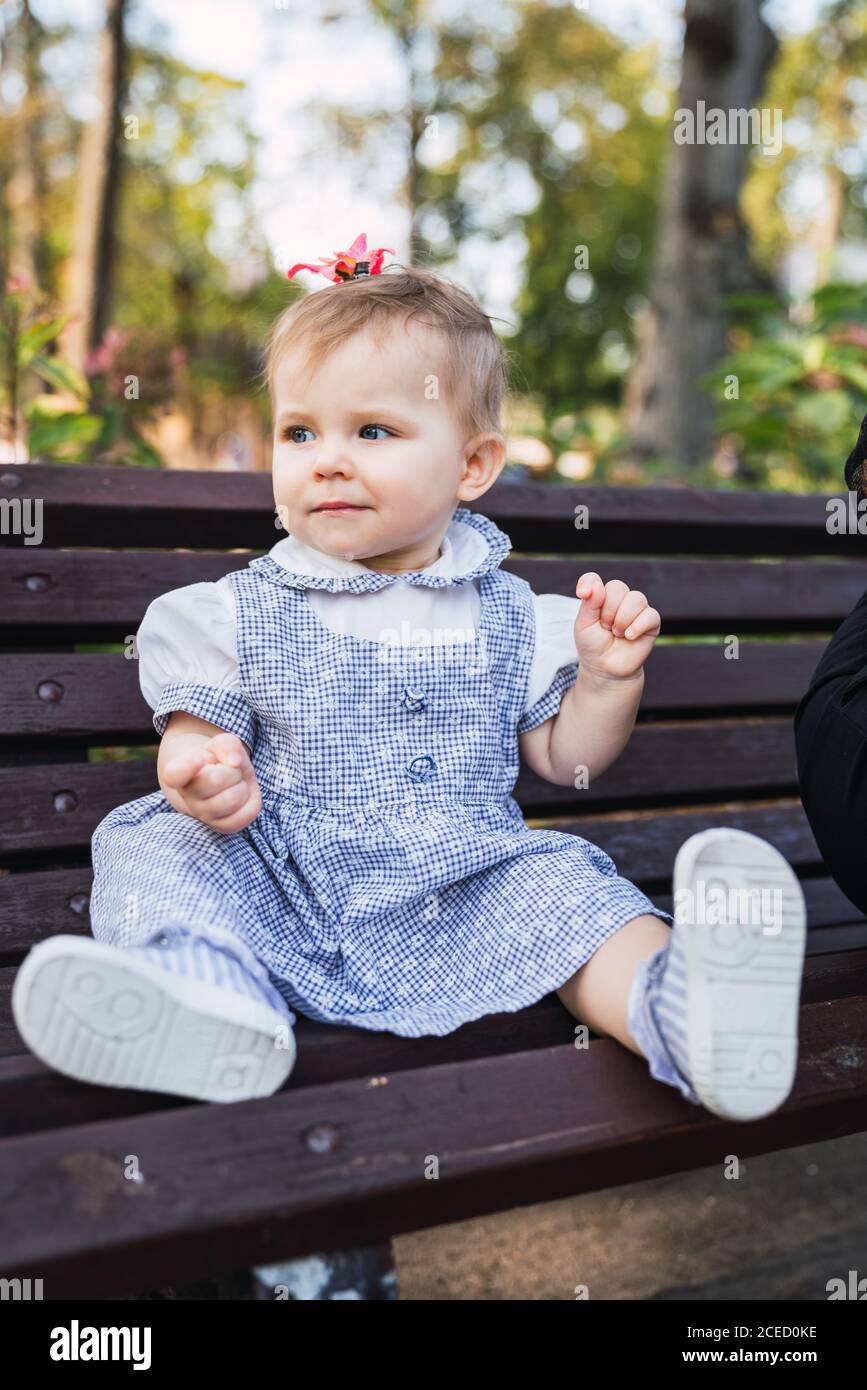 Baby girl sitting on bench Stock Photo - Alamy