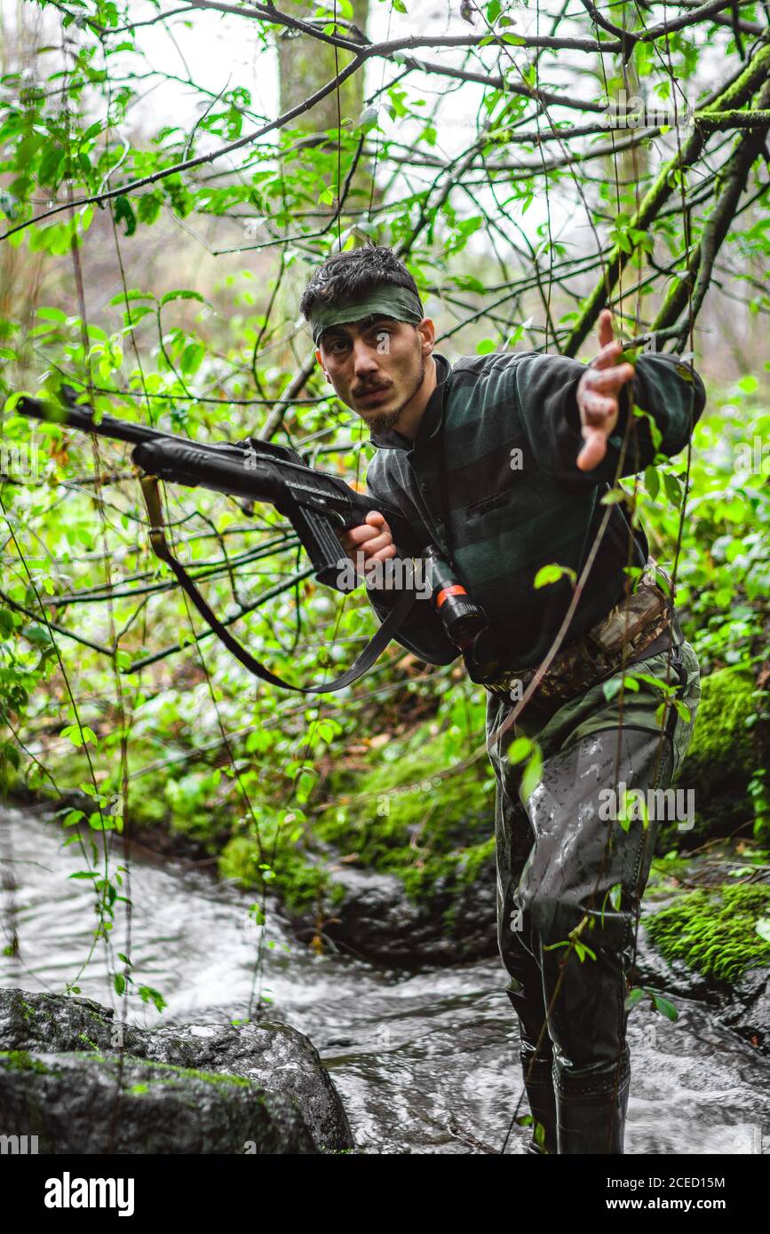 Soldier or revolutionary member or hunter in camouflage in the river ...