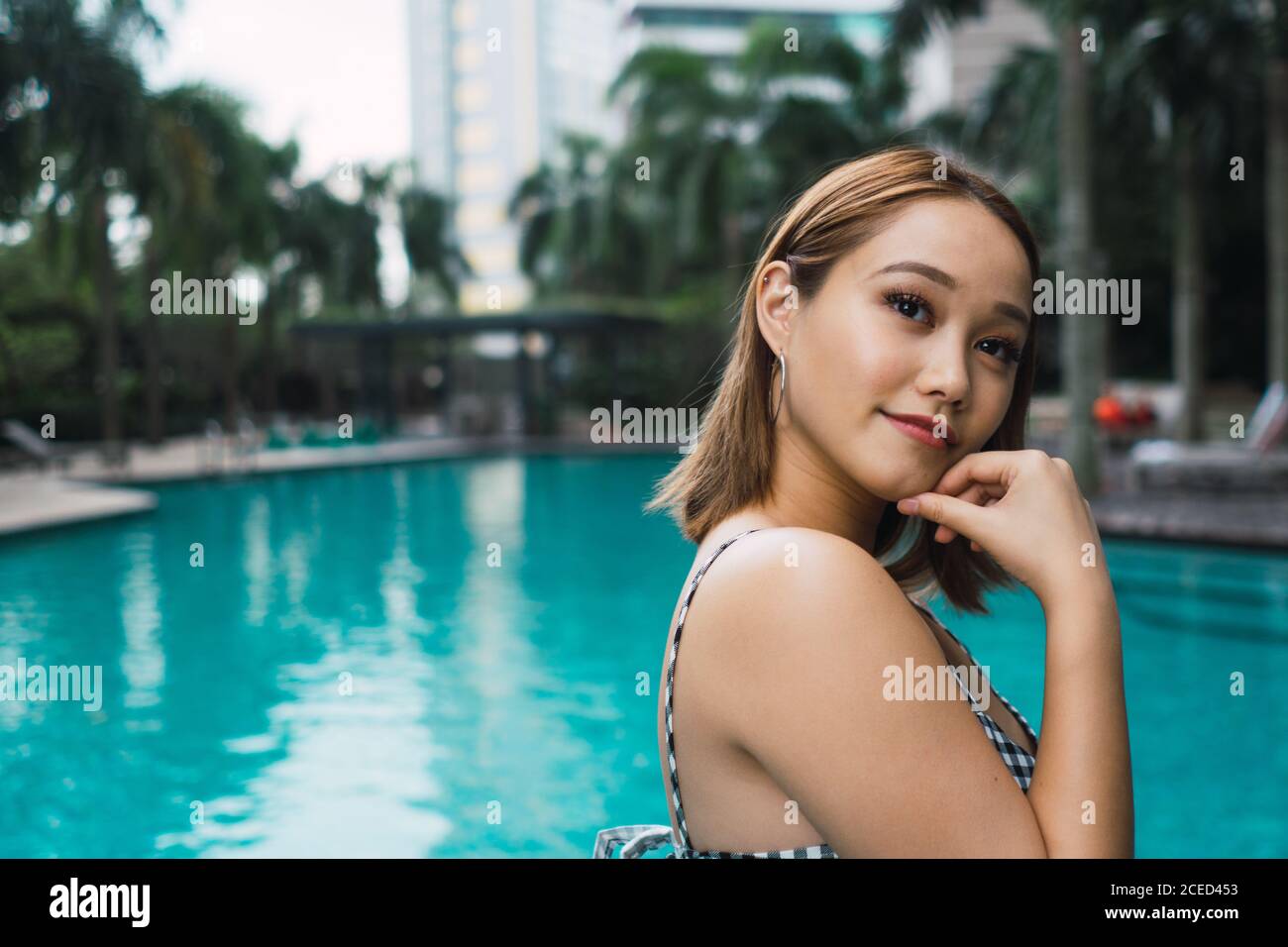 Beautiful woman standing poolside hi-res stock photography and images - Alamy