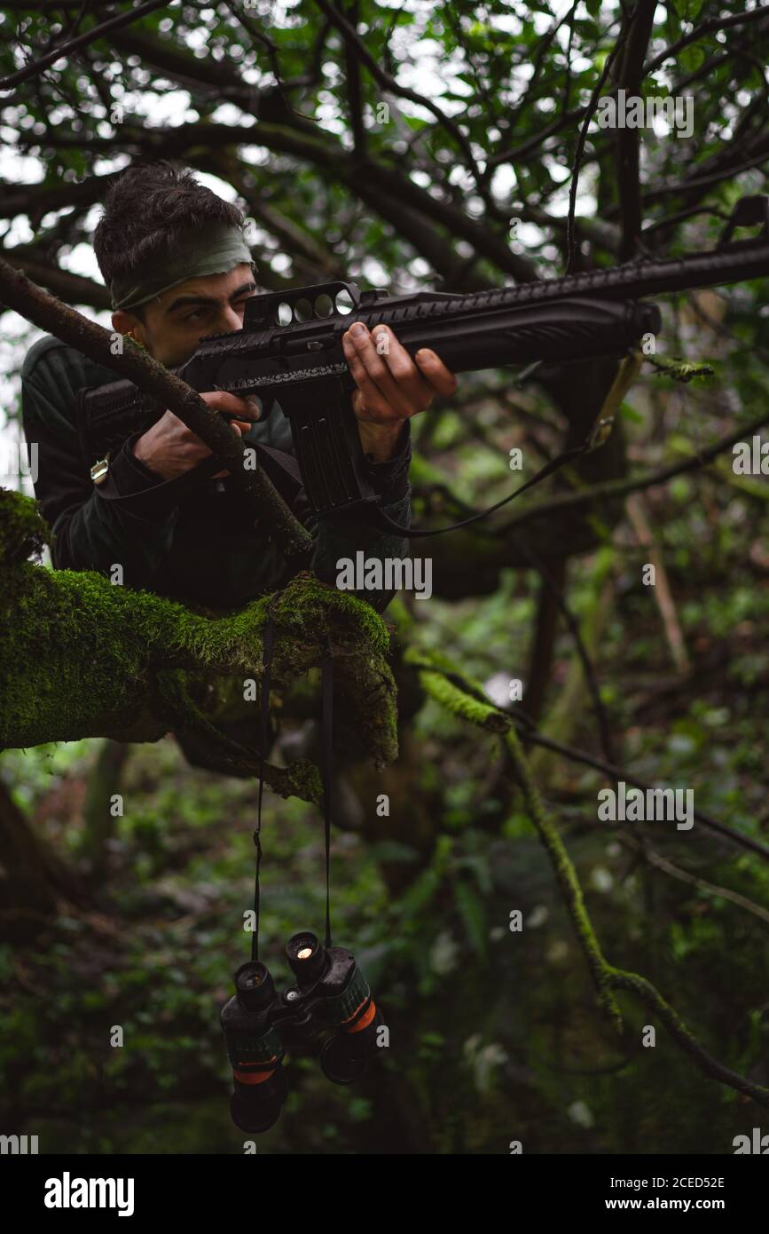 Soldier or revolutionary member or hunter in camouflage on the tree ...