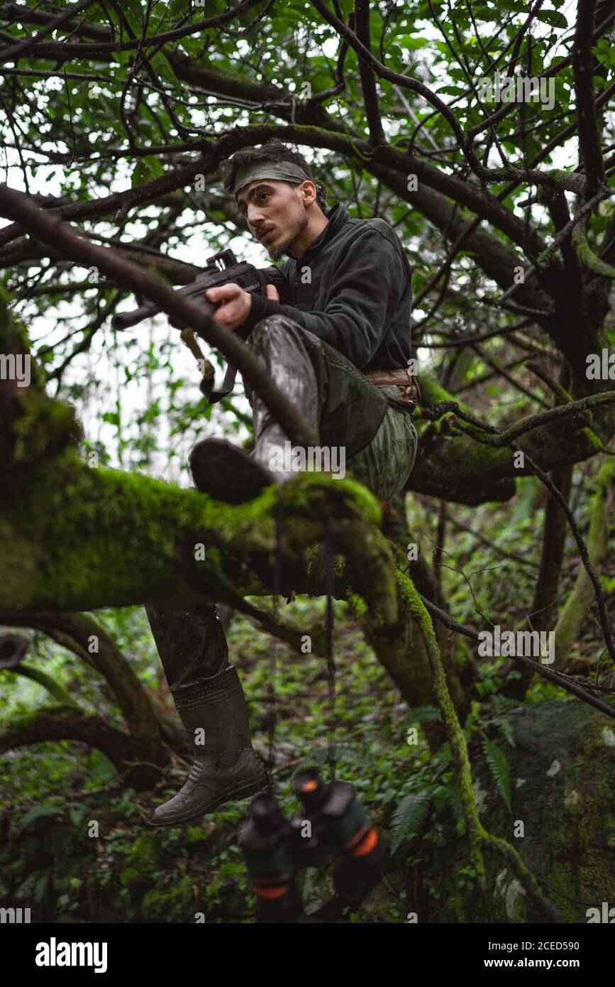 Soldier or revolutionary member or hunter in camouflage on the tree ...