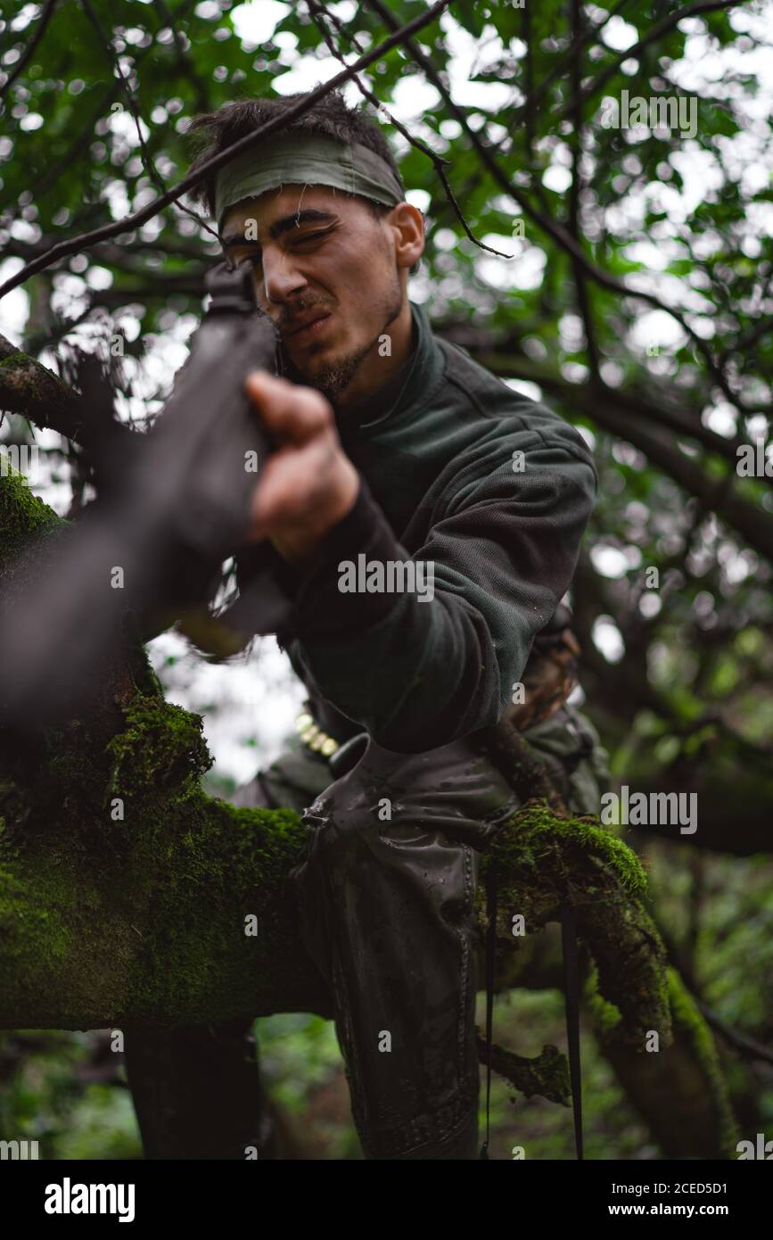 Soldier or revolutionary member or hunter in camouflage on the tree ...