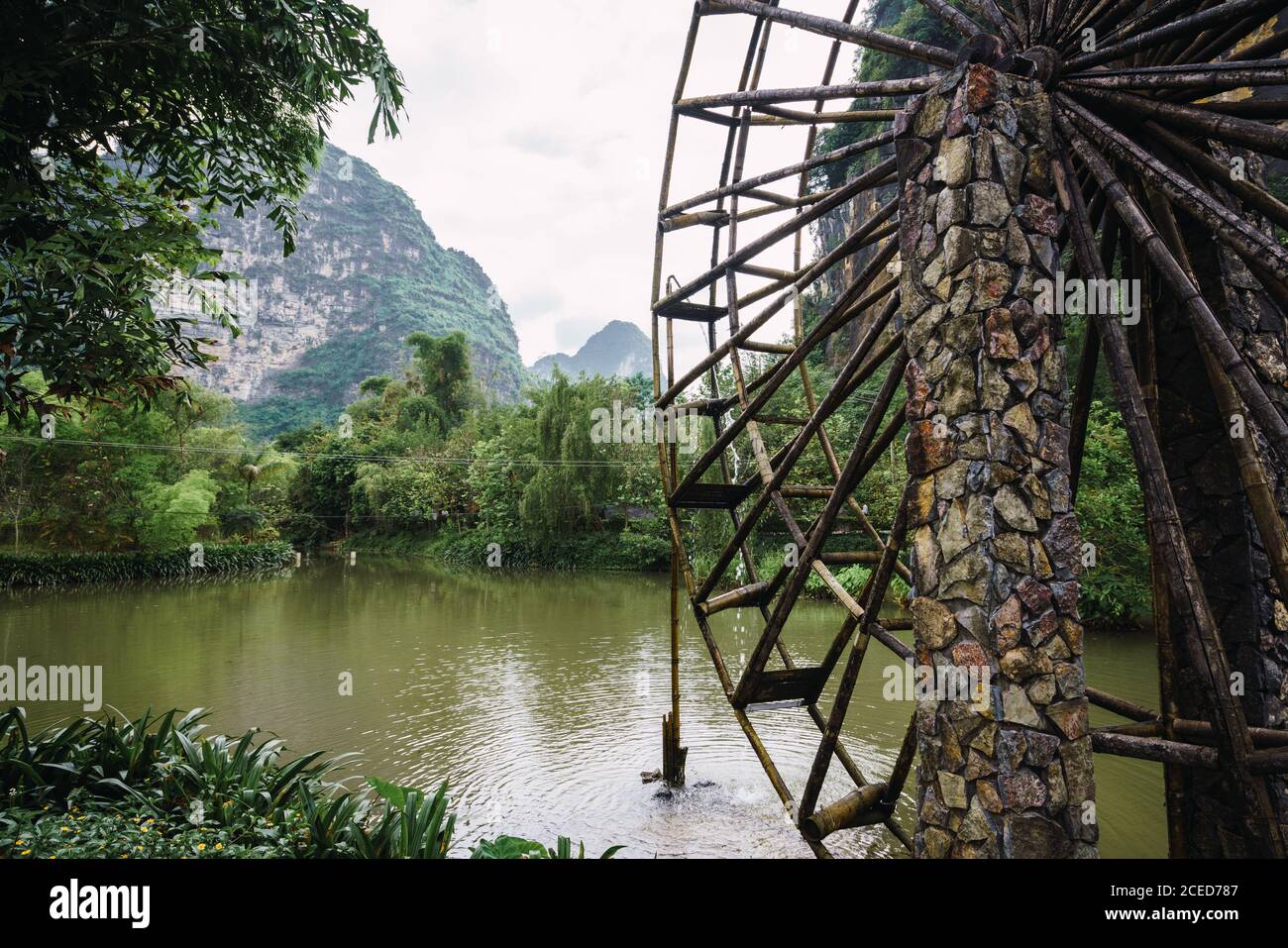 Beautiful wooden waterwheel of old stone watermill surrounded by trees ...