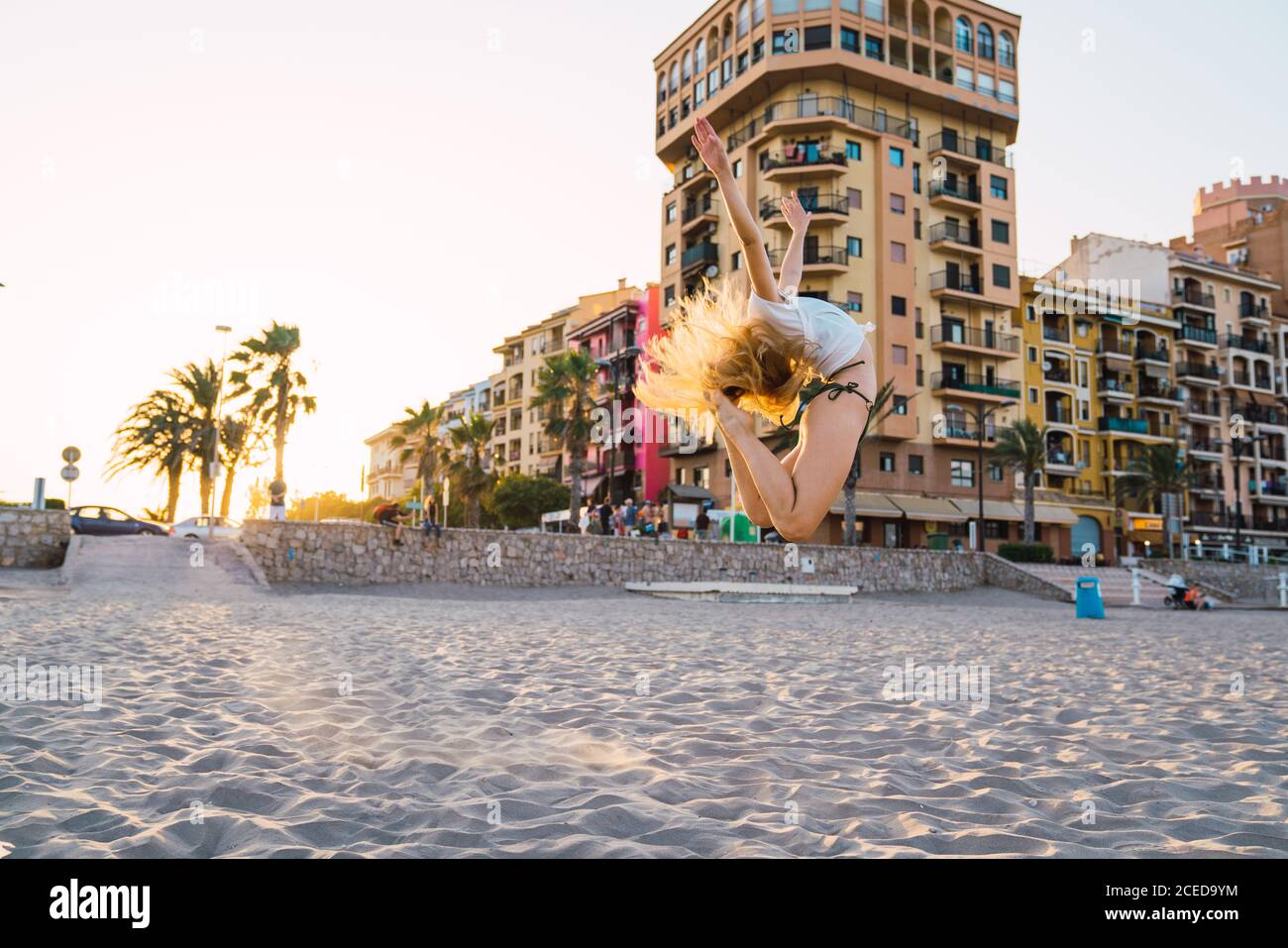 Flexible Woman standing on one leg on beach Stock Photo - Alamy