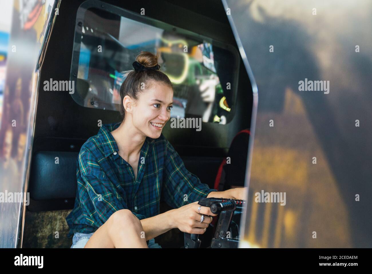Woman playing arcade machine Stock Photo - Alamy